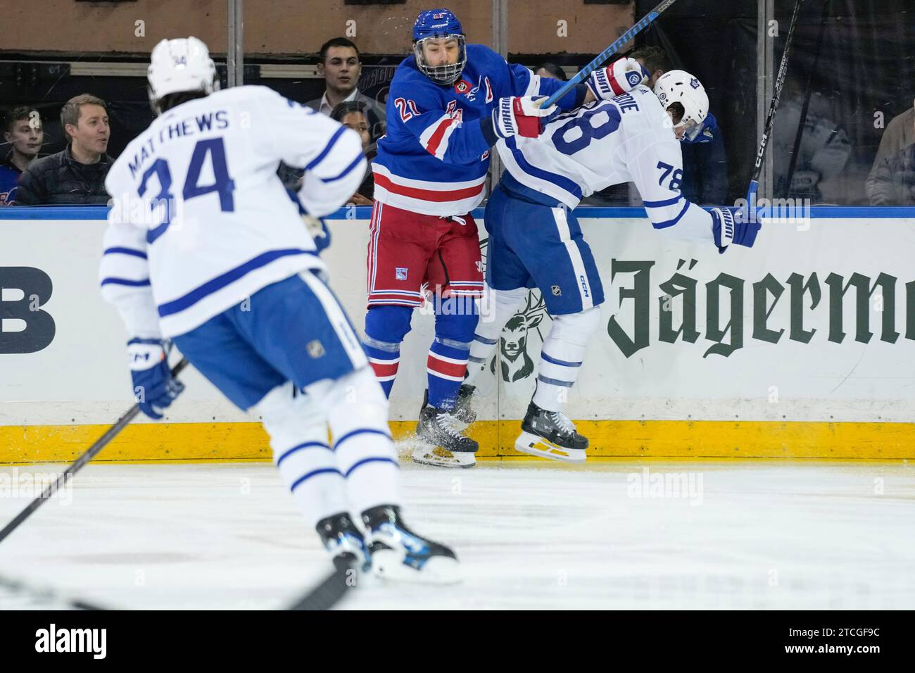New York Rangers' Barclay Goodrow, center, hits Toronto Maple Leafs' TJ ...