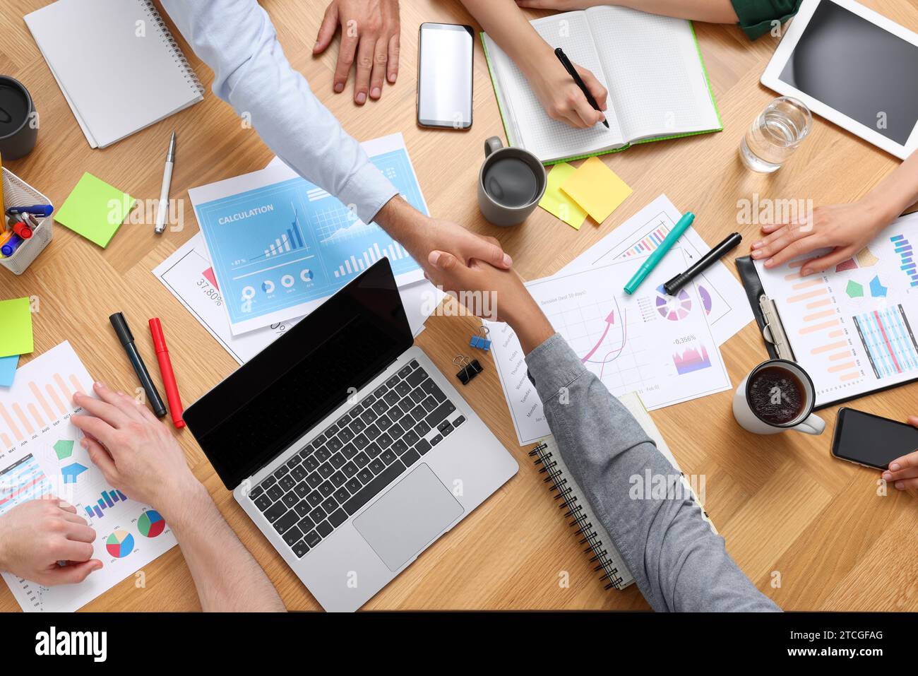 Team of employees working together at wooden table, top view. Startup ...