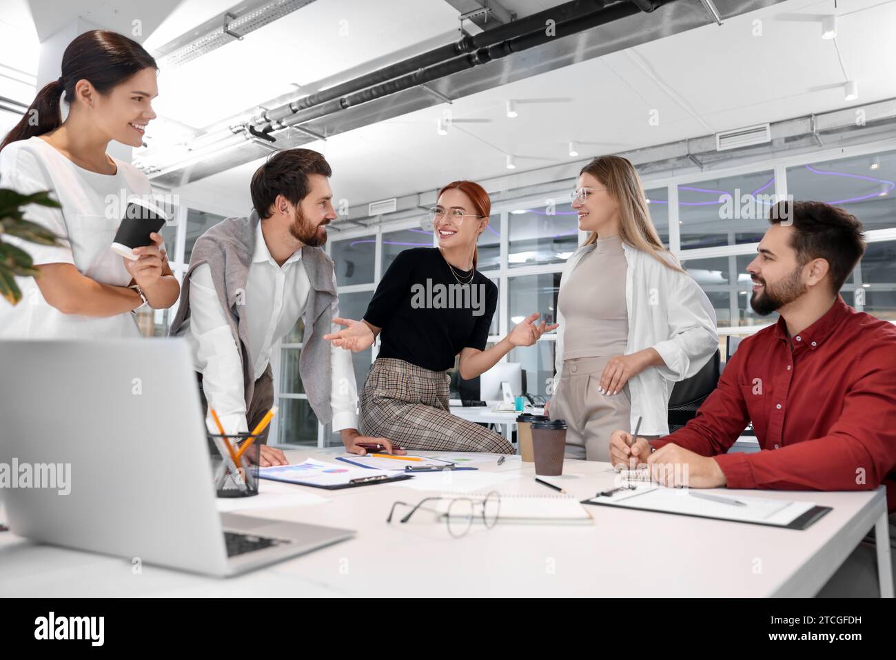 Team of employees working together in office Stock Photo - Alamy