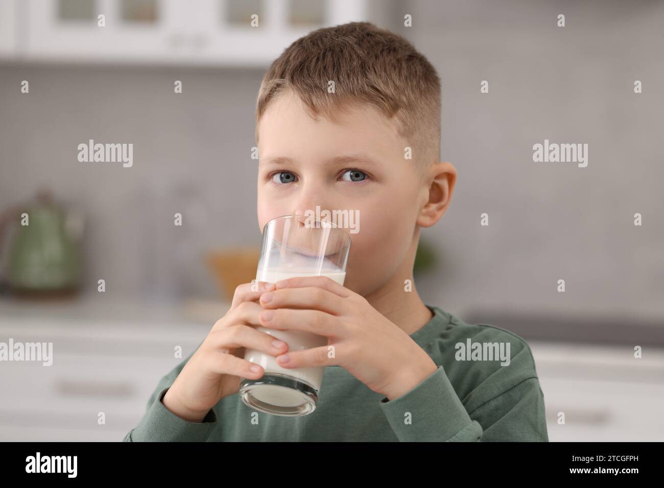 Cute boy drinking fresh milk from glass indoors Stock Photo - Alamy