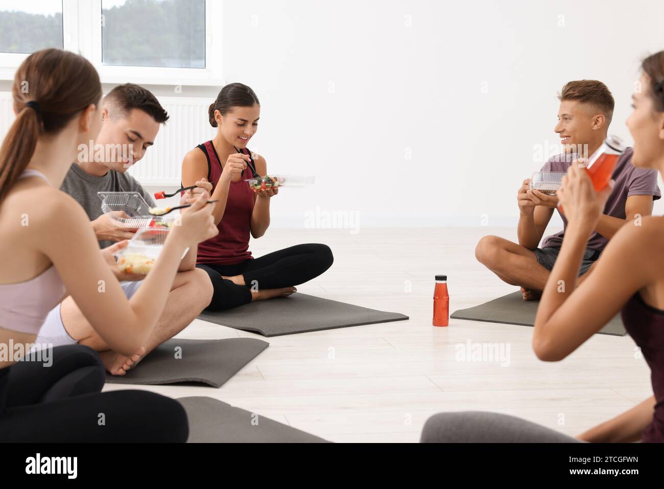 Group of people eating healthy food after yoga class indoors Stock ...