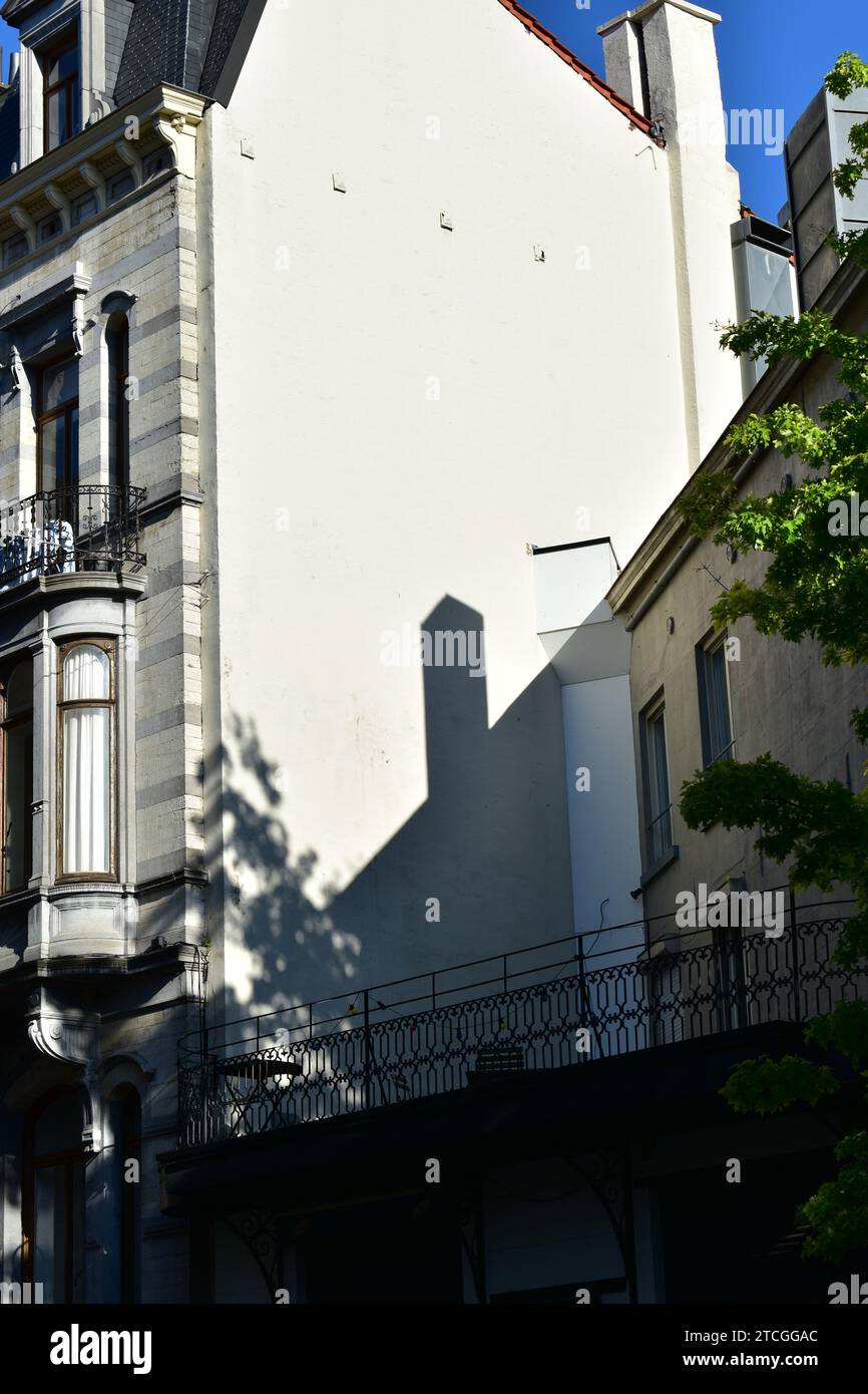 Shadow of a rectangular brick chimney on a large white wall in the ...