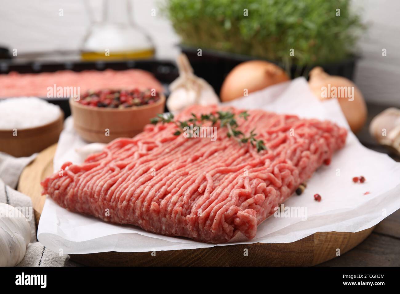Fresh raw ground meat, thyme and peppercorns on table, closeup Stock ...