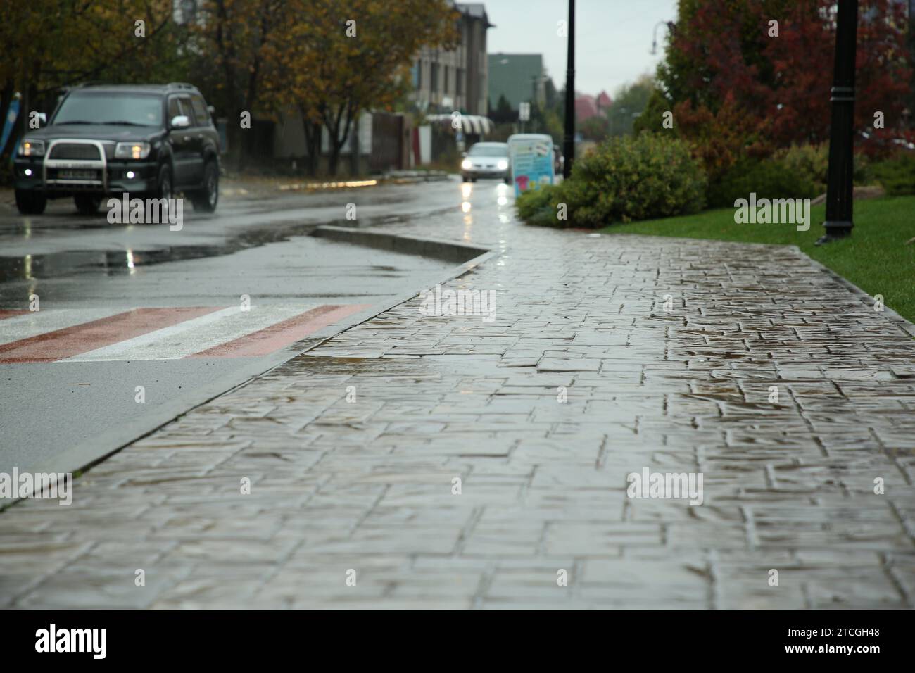 City street with puddles on pavement after rain Stock Photo - Alamy