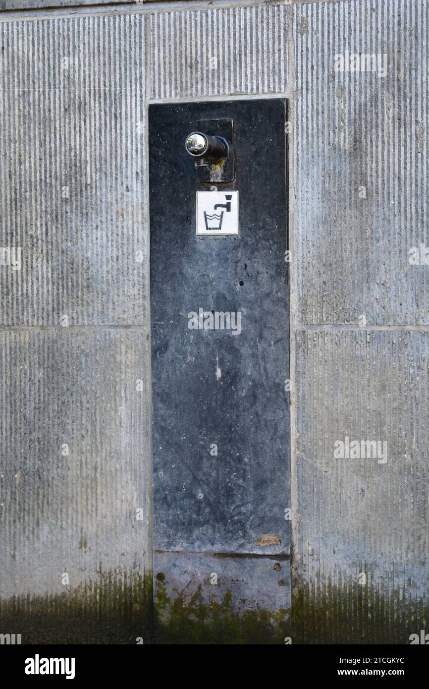 Small public faucet for drinking water on blue stone background wtih ...