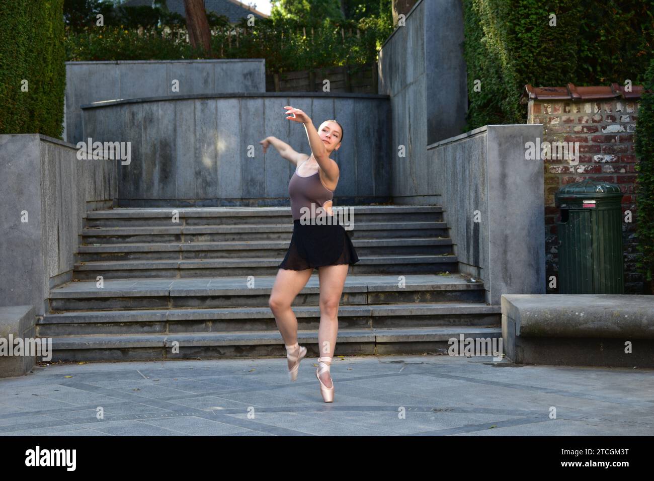 Young woman in purple top and black skirt performing a ballet pose on ...