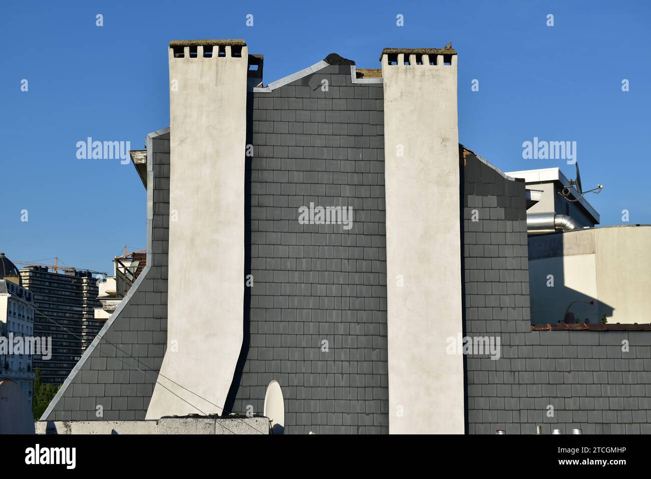 Two white rectangular concrete chimneys running along the side of a ...