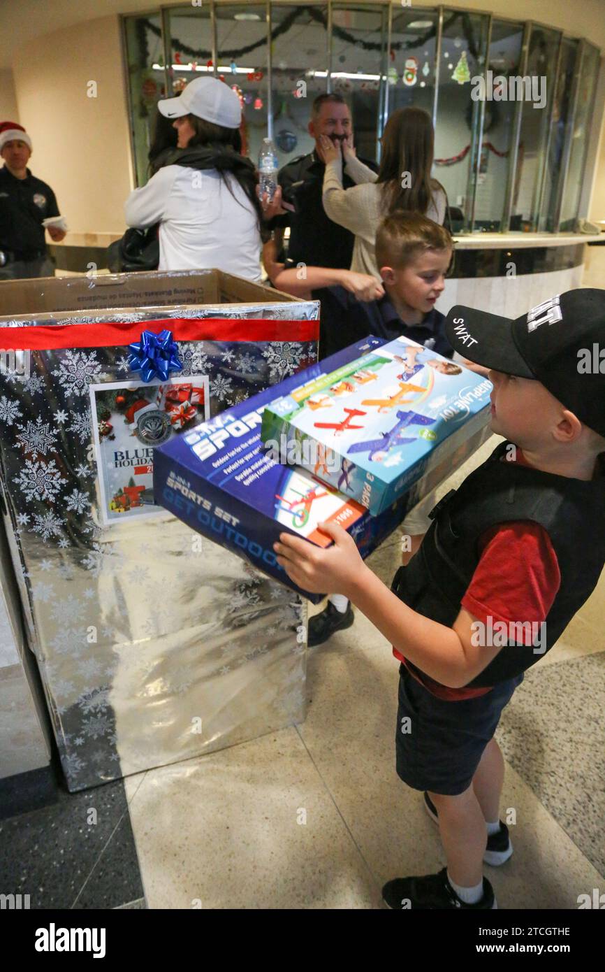 Children bring toys to the donation box at the Gilbert Police ...
