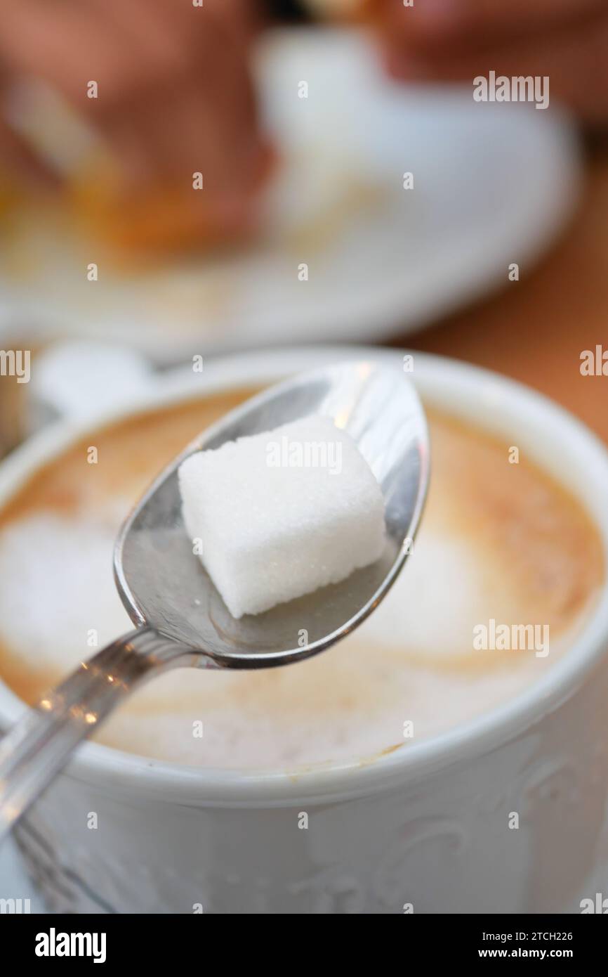dropping sugar cube in a coffee cup Stock Photo - Alamy