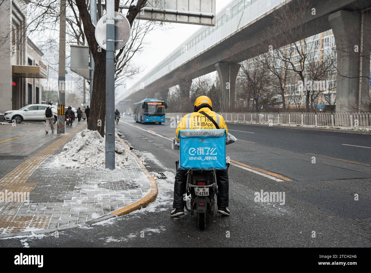 Beijing, China. 13 Dec, 2023. Food delivery worker on bike, icy roads ...