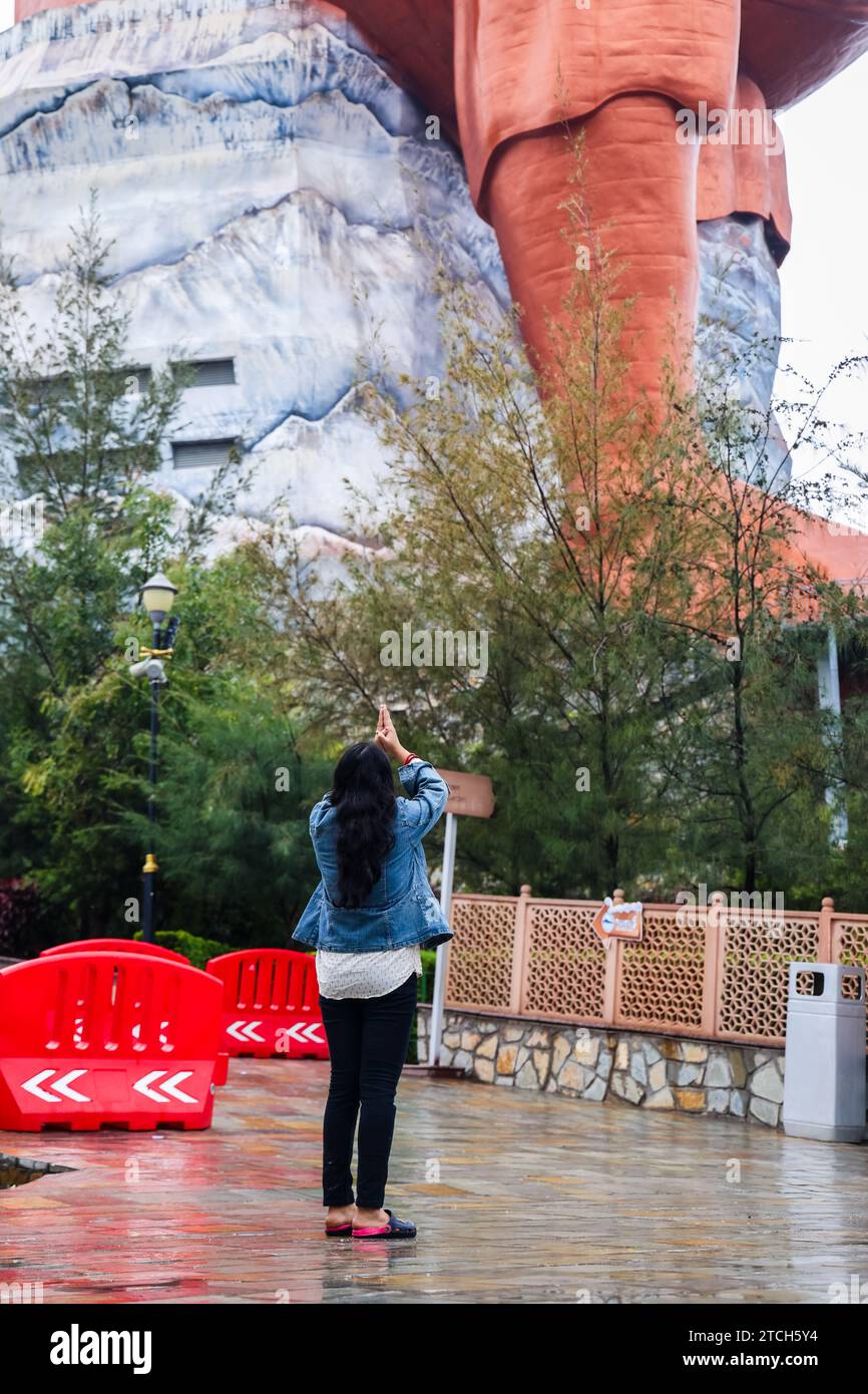 young girl paying salutation to hindu god lord shiva statue at morning ...