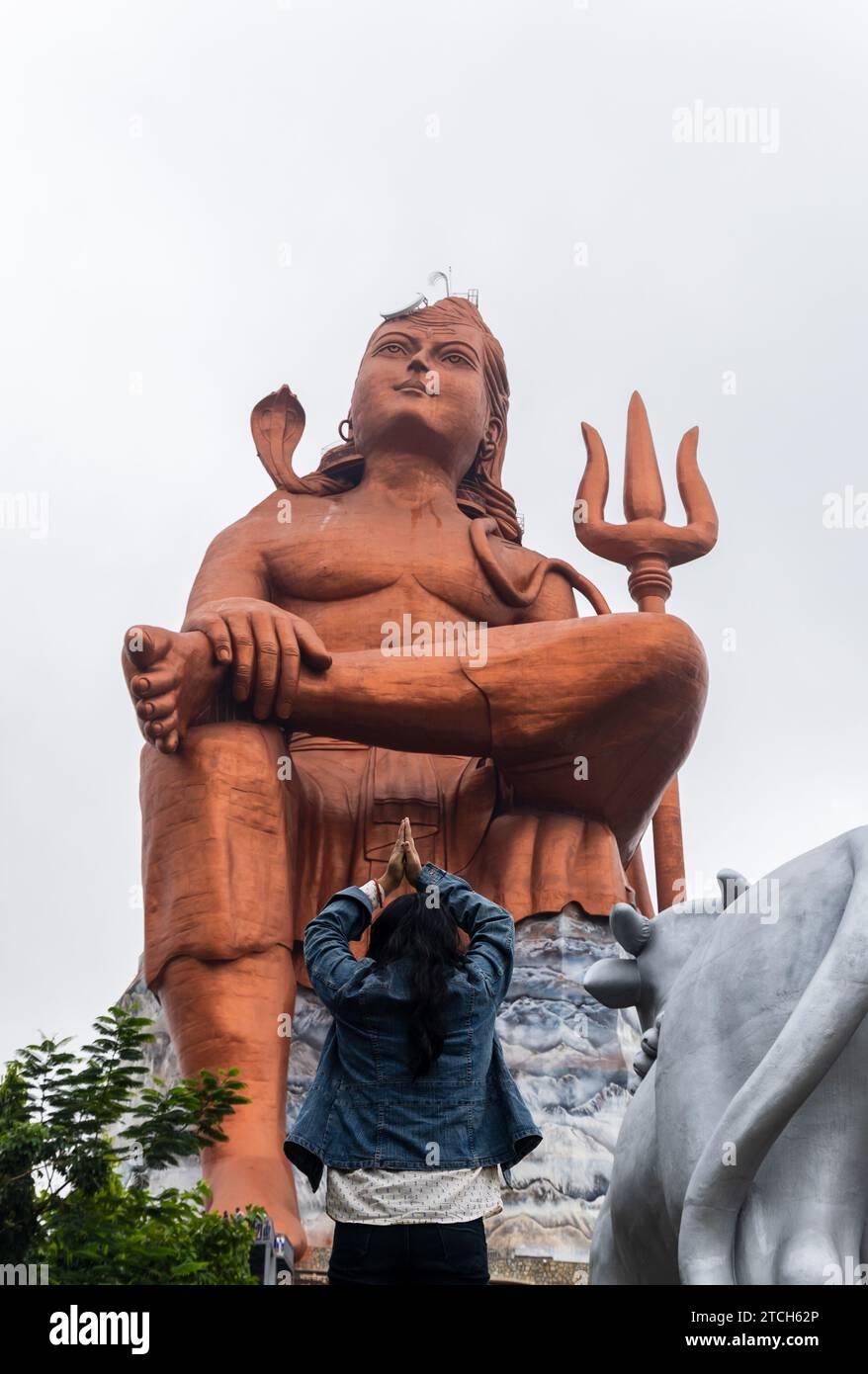 young girl paying salutation to hindu god lord shiva statue at morning ...