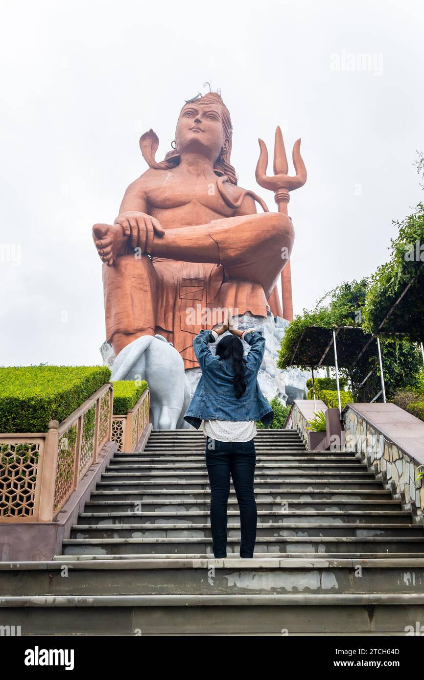 young girl paying salutation to hindu god lord shiva statue at morning ...
