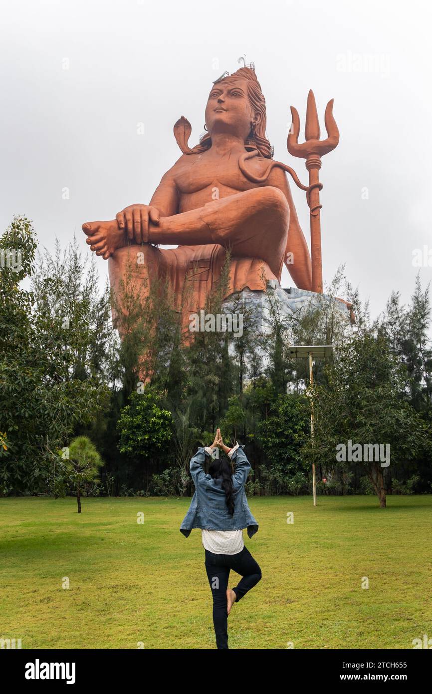 young girl paying salutation to hindu god lord shiva statue at morning ...