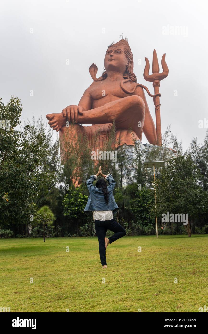 young girl paying salutation to hindu god lord shiva statue at morning ...