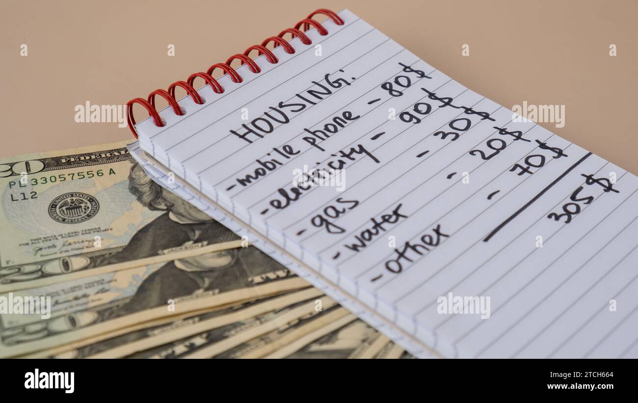Dollar cash money with notebook handwritten housing expenses. Counting ...