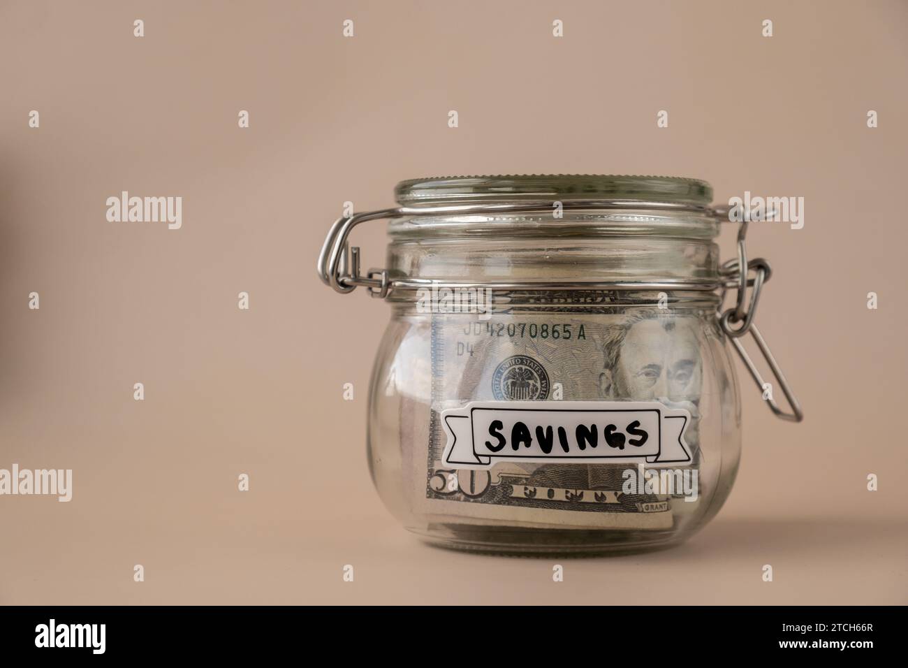 Saving Money In Glass Jar filled with Dollars banknotes. SAVINGS ...