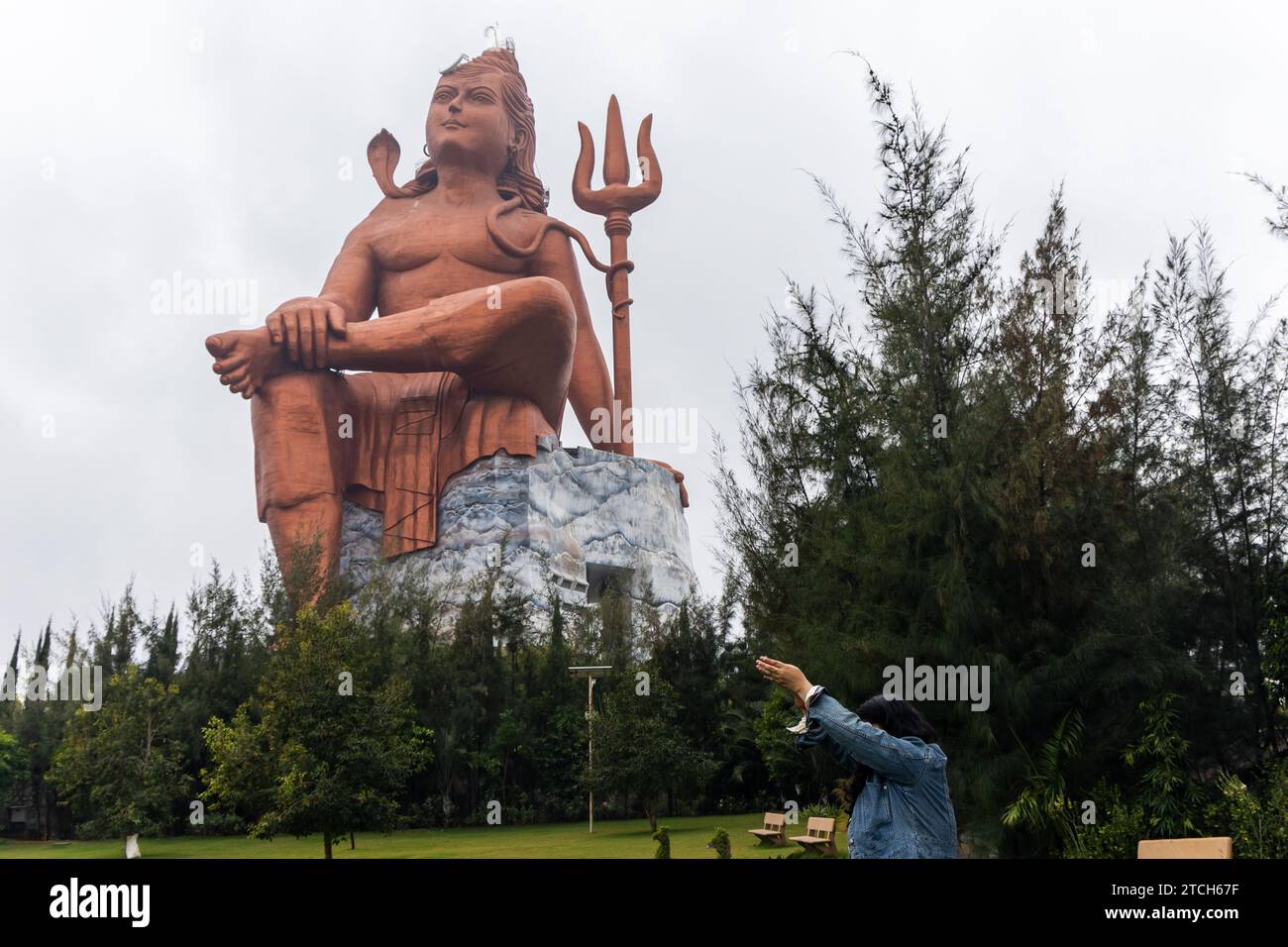 young girl paying salutation to hindu god lord shiva statue at morning ...