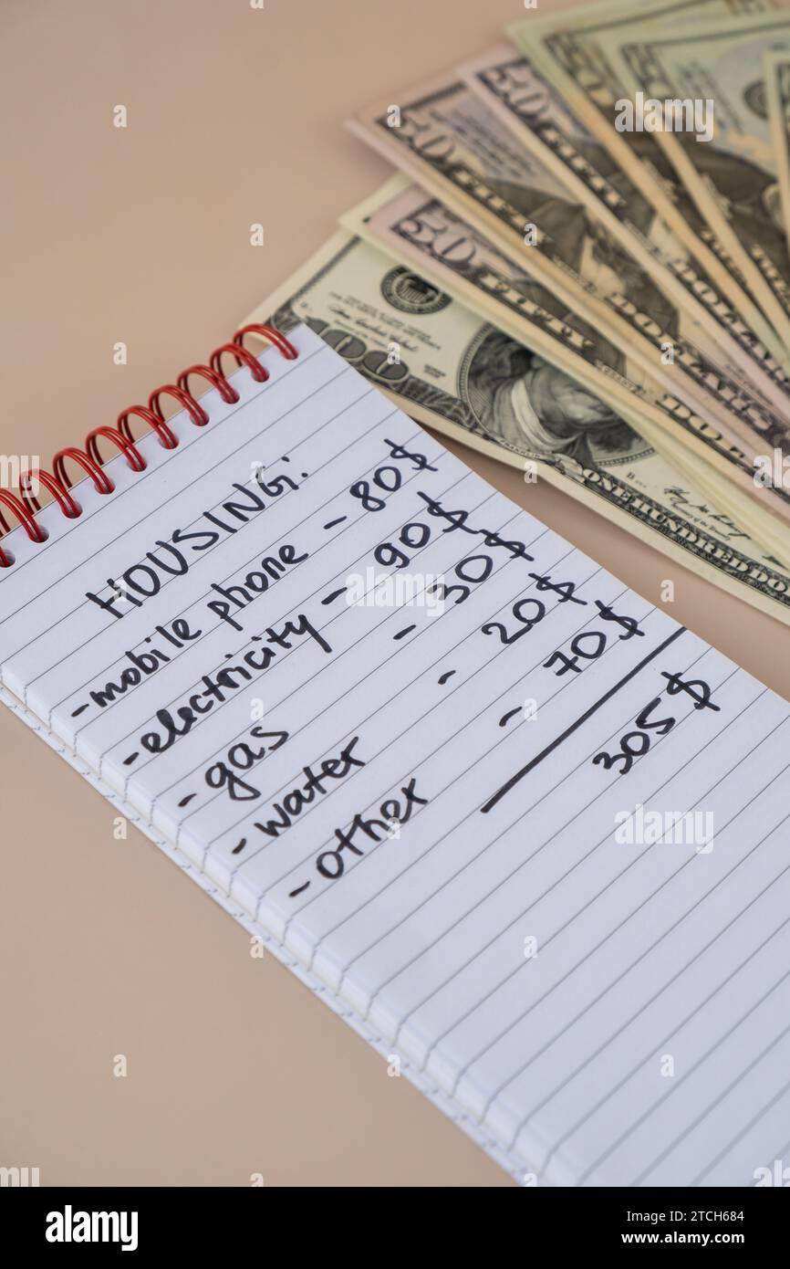 Dollar cash money with notebook handwritten housing expenses. Counting ...