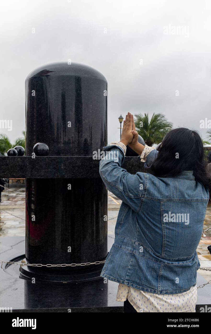 devotee paying salutation to hindu religious symbol Shivalinga at ...