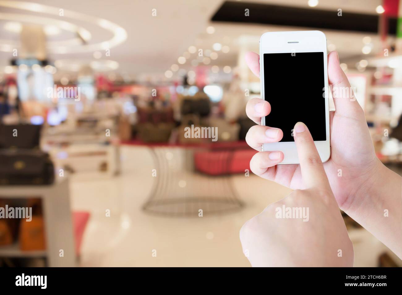 hand holding smartphone with shopping mall store blur background with ...