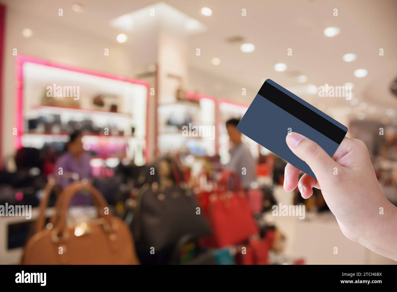 Female hand holding credit card with shopping mall background Stock ...