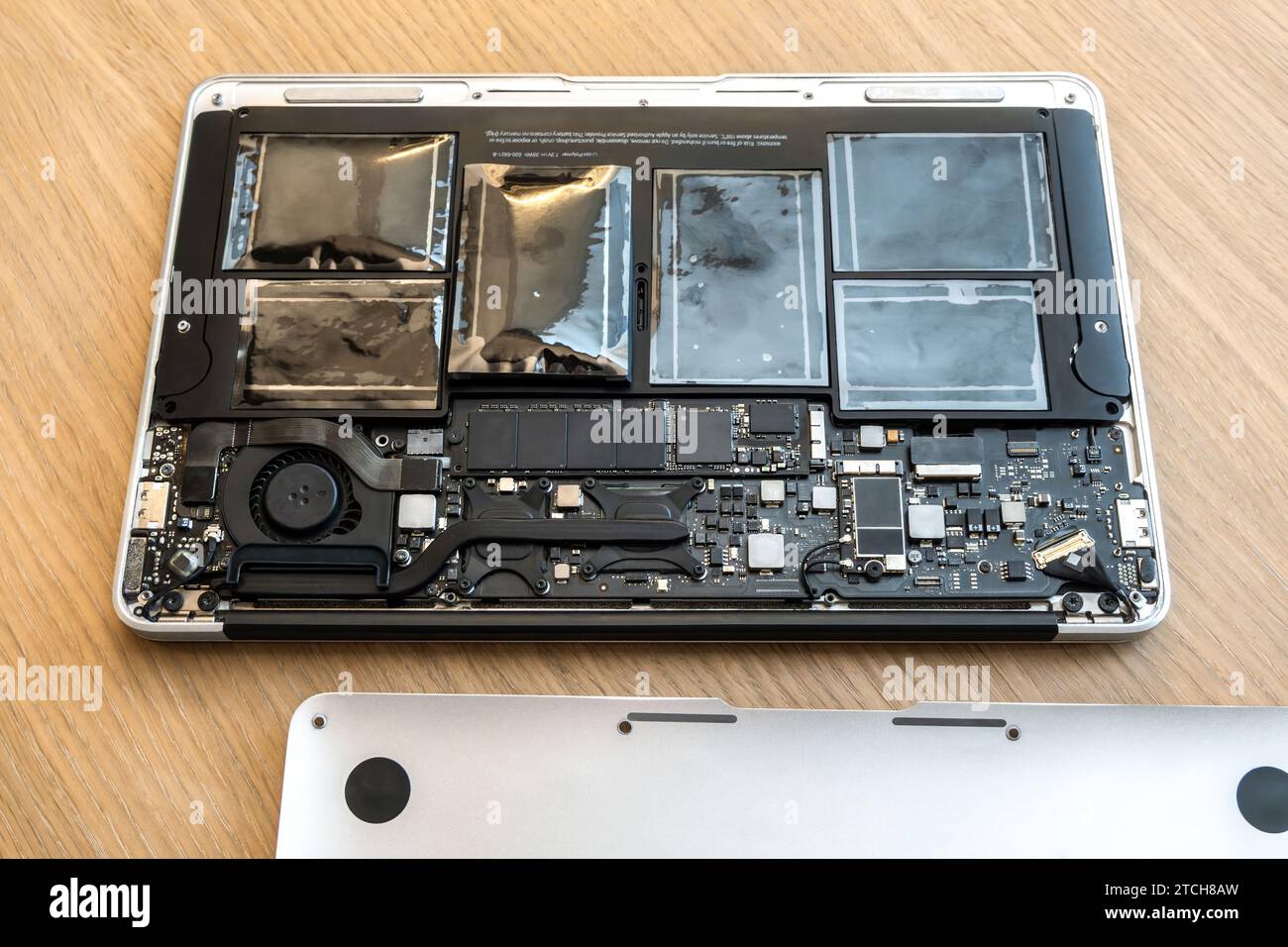 Swollen battery of broken laptop in open casing closeup. Heavy damage ...
