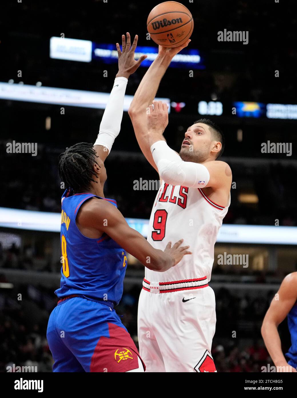 Chicago Bulls center Nikola Vucevic shoots over Denver Nuggets forward ...