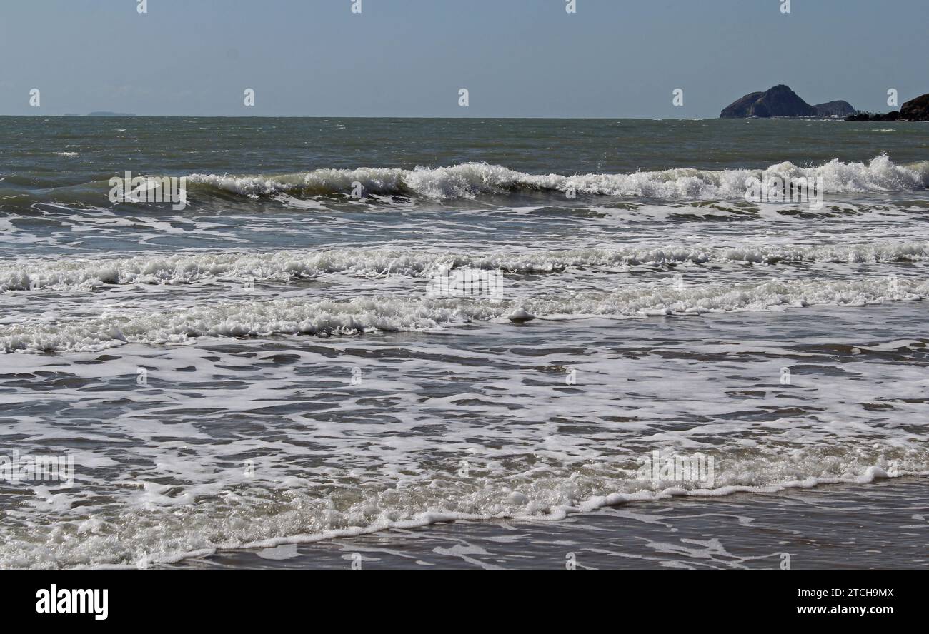 Waves of an ocean sea water crashing onto the sand of a beach Stock ...