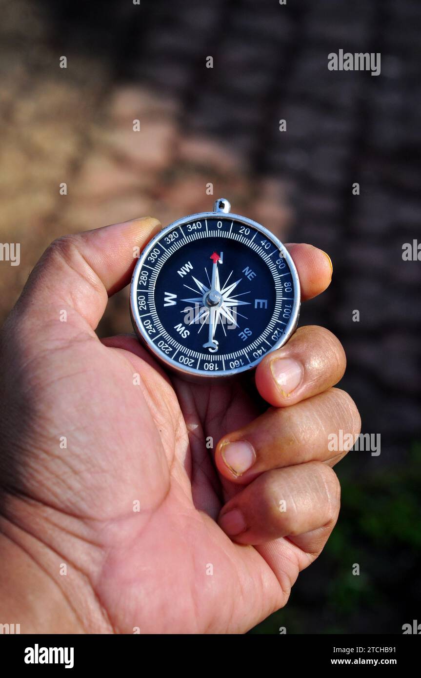 Hand holding a compass with blur background Stock Photo - Alamy