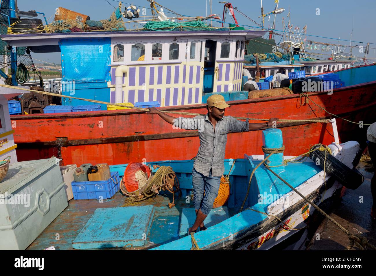 A fisherman on a fishing trawler anchored at the Old Port in Mangalore ...