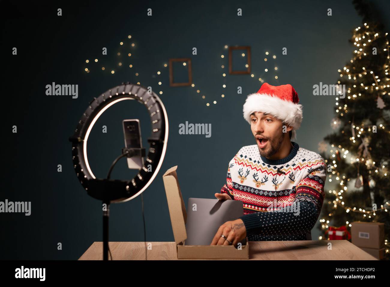 Arab blogger unboxing Christmas parcel with laptop on camera, taking ...