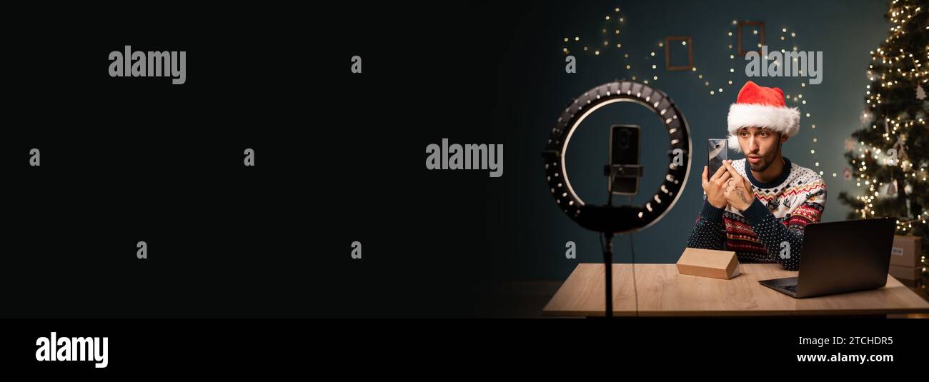 Young Arab blogger unpacking parcel with new smartphone on camera while ...