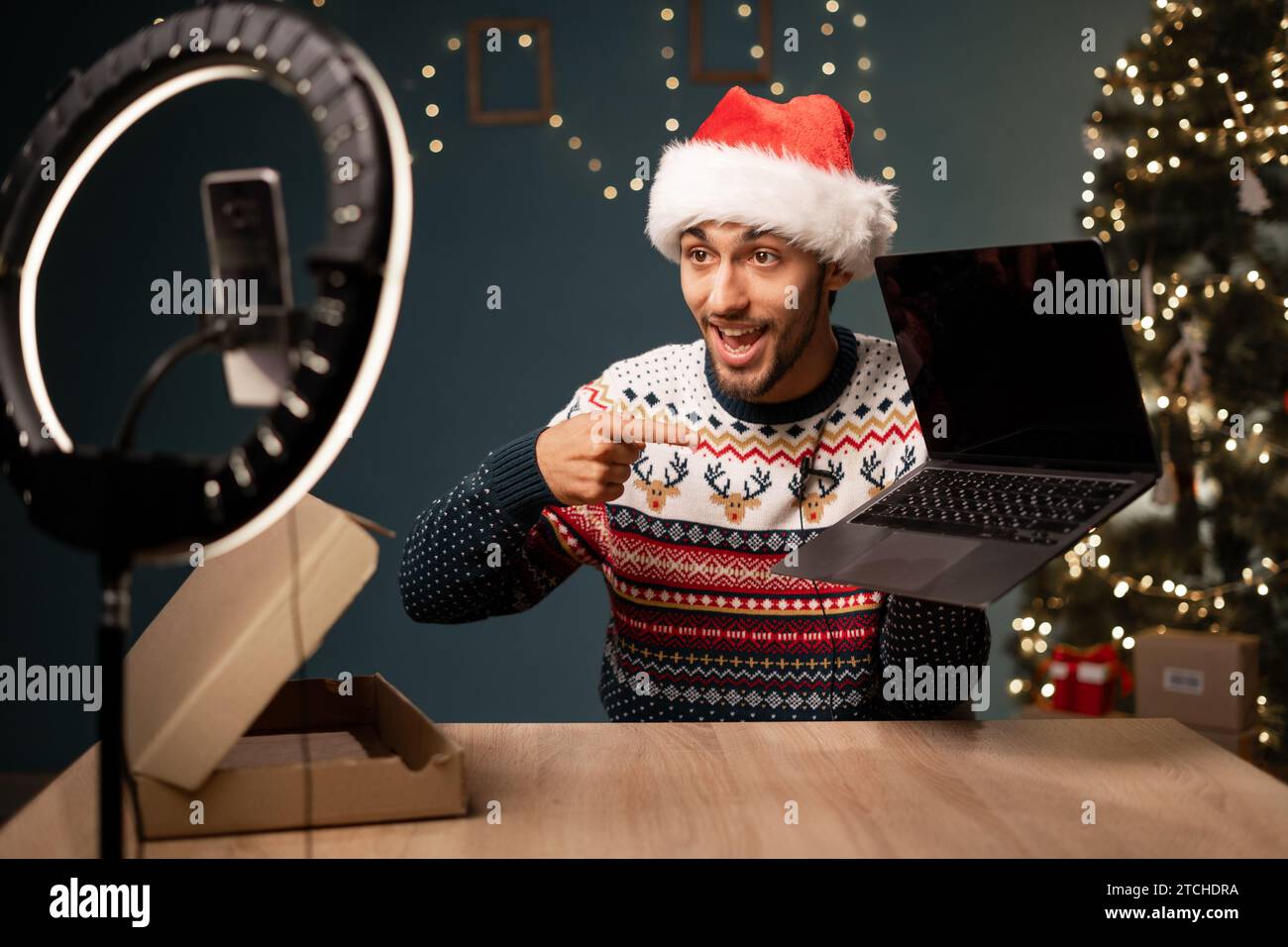 Young arab male blogger unboxing christmas parcel with new laptop on ...