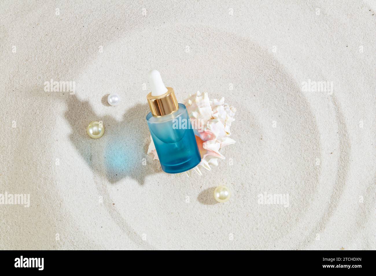 A bottle of serum stands out with sea shells on a sandy background ...