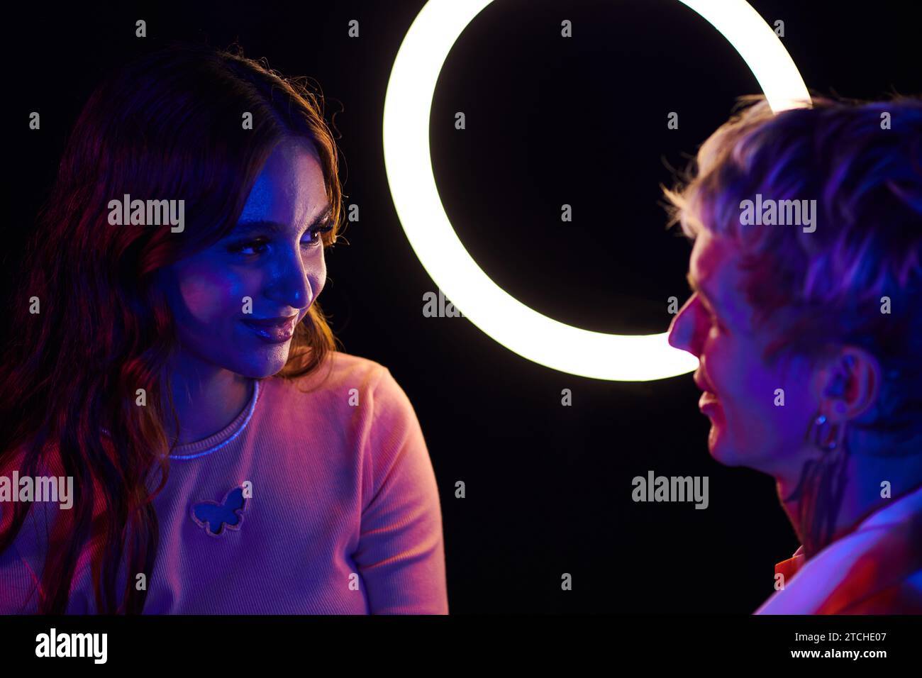 Smiling young man and woman talking at night party Stock Photo - Alamy