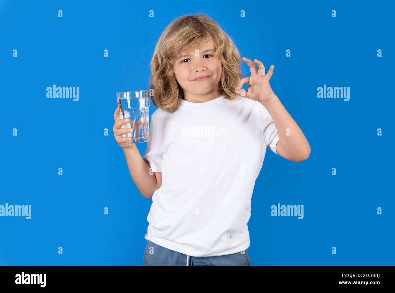 Kid drinking water, isolated on studio background. Cute blonde child ...