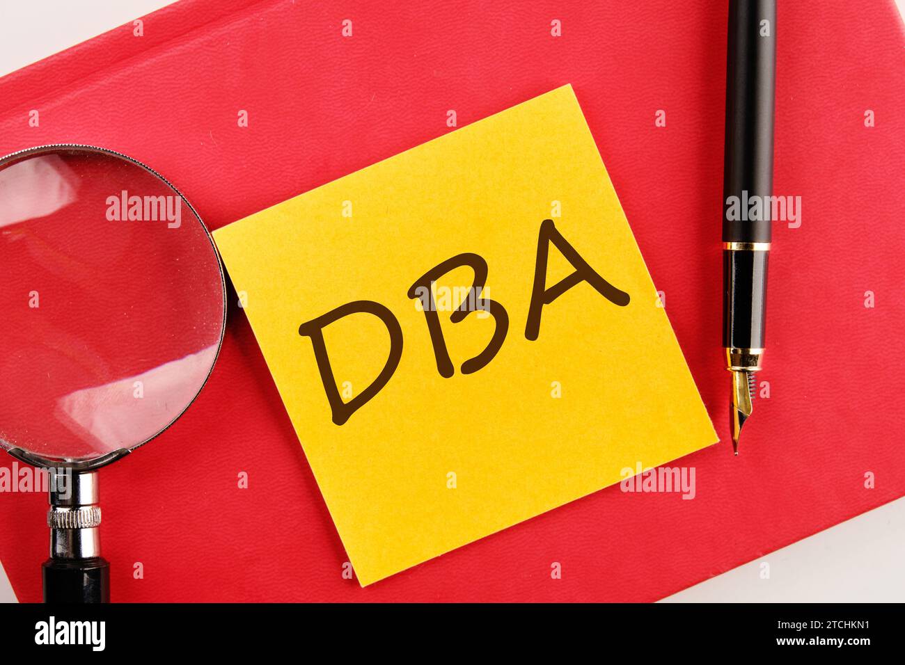 DBA the inscription on the sticker lying on a red notebook next to a ...