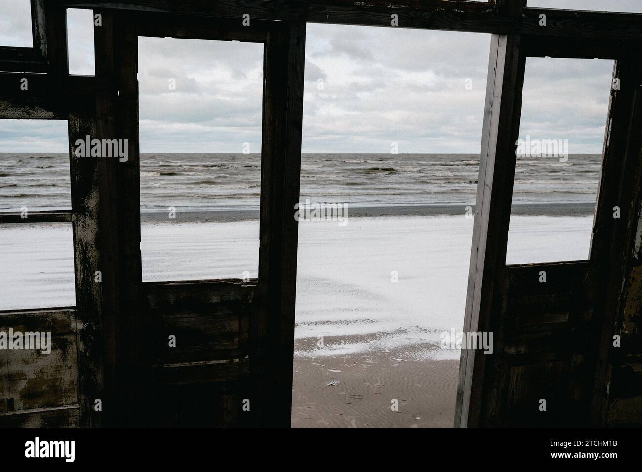 A stunning seascape view of Liepaja, Latvia through a rustic window ...