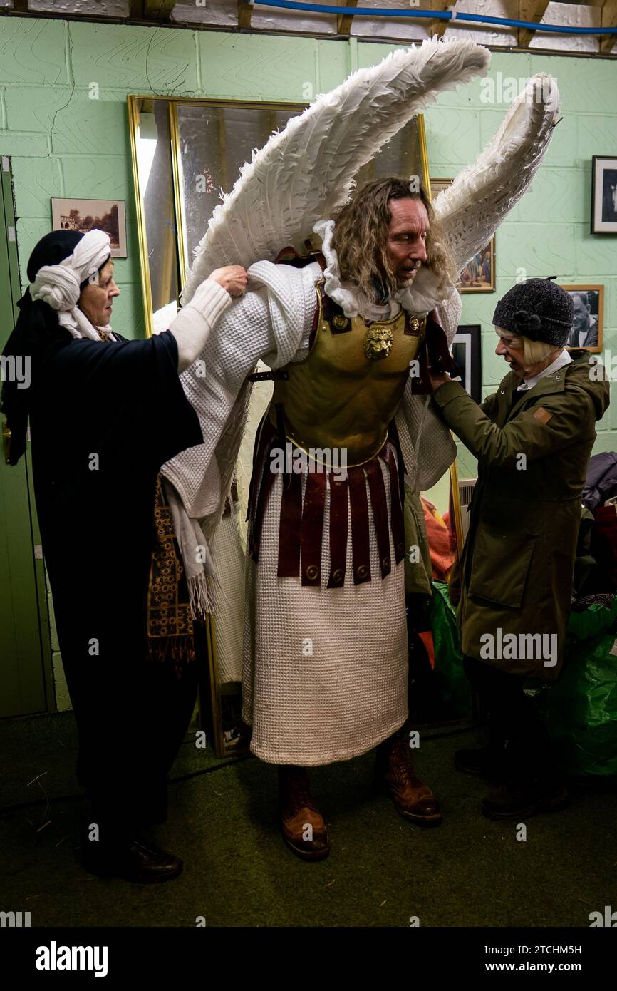 An actor playing Archangel Gabriel is helped into costume during the ...