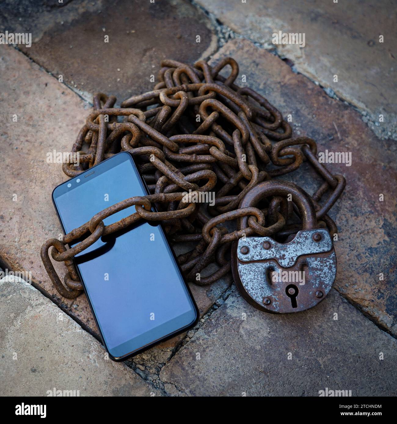 An iron chain with a lock binds the smartphone. The concept of cell ...