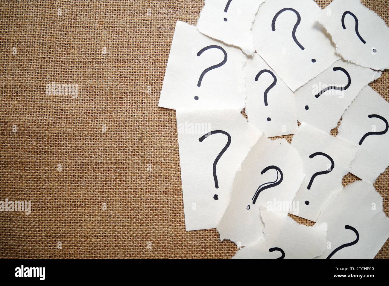 Torn paper showing question mark symbol on yellow background with copy ...