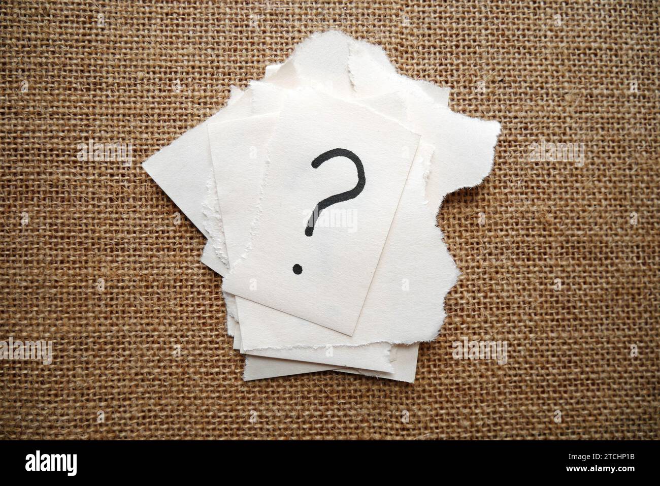 Torn paper showing question mark symbol on yellow background with copy ...