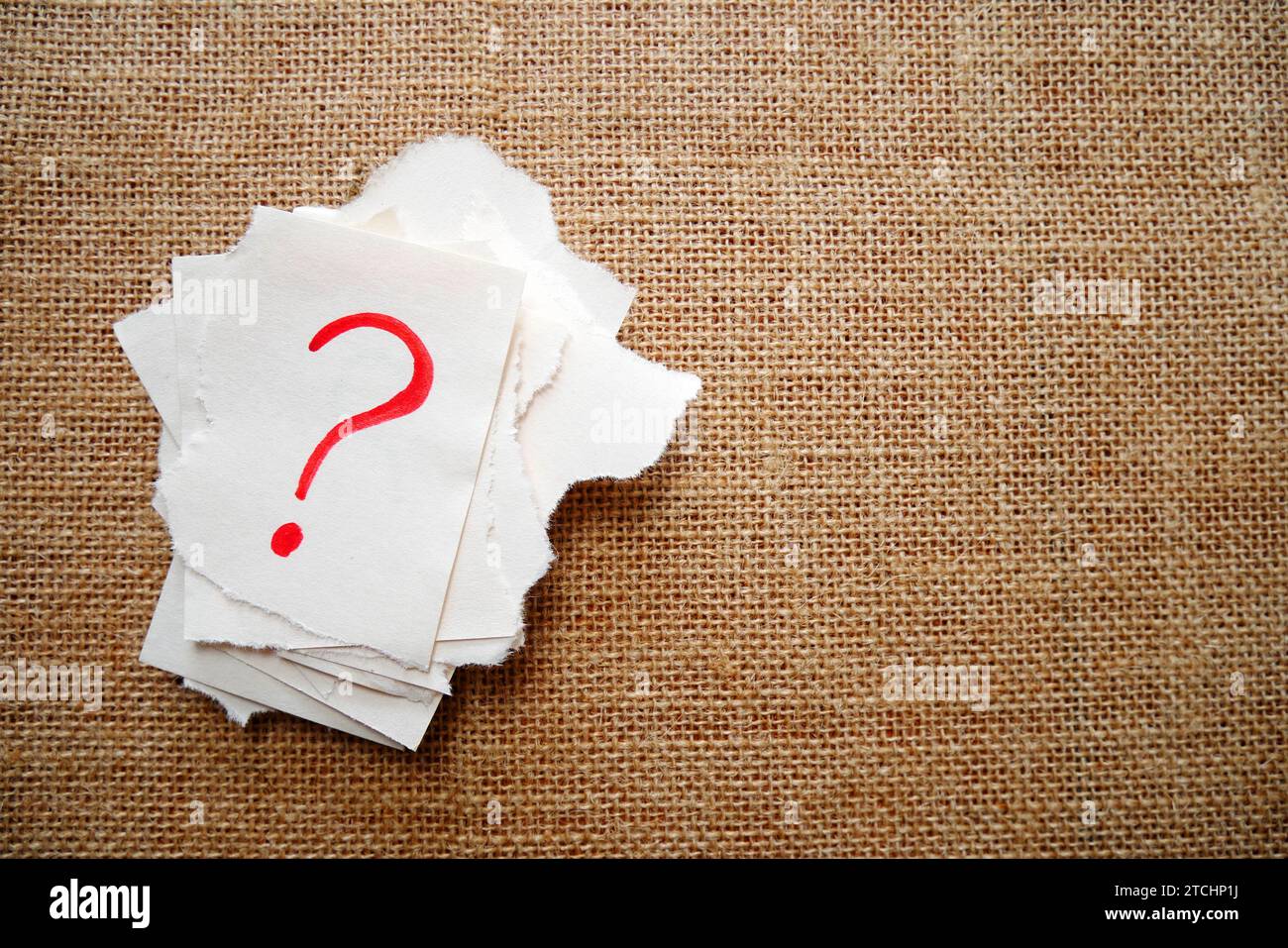 Torn paper showing question mark symbol on yellow background with copy ...