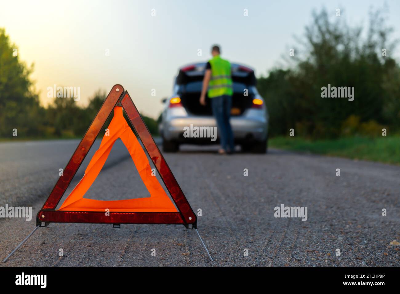 Broken silver luxury car emergency accident. Man driver installing red ...