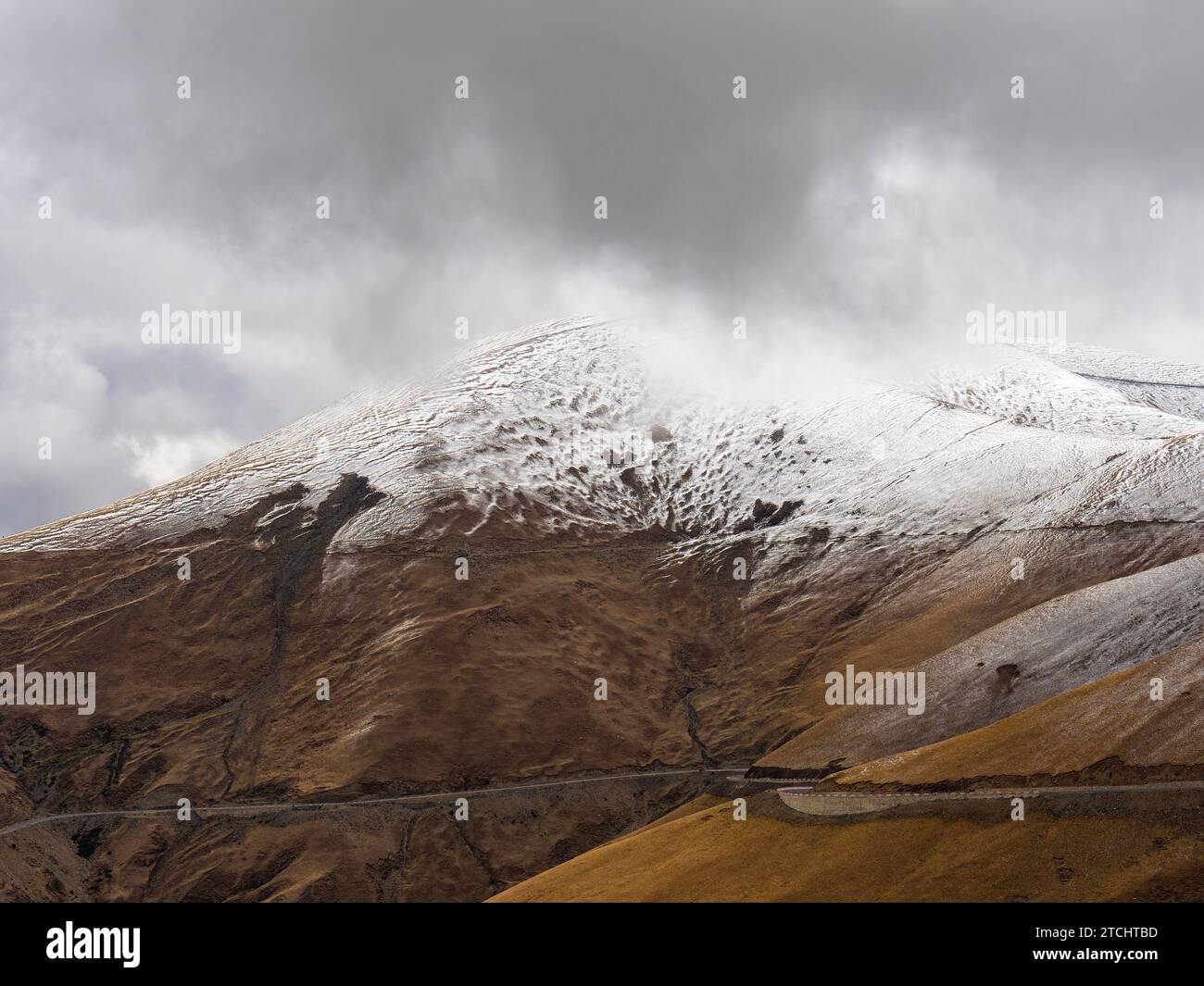 Mountain ridge with clouds and snow at Kampala Pass, highlands of Tibet ...