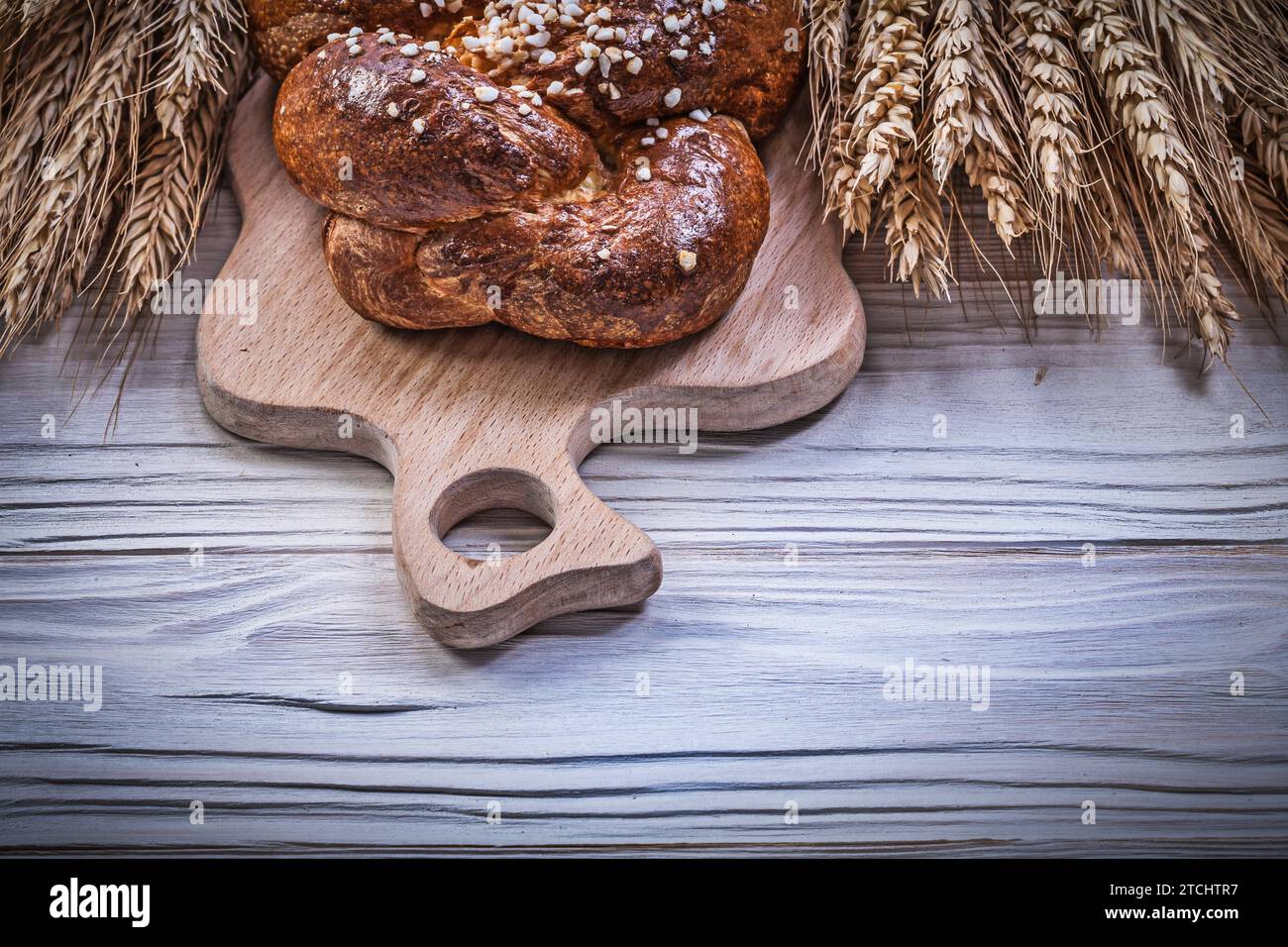 Carving board wheat rye ears sweet bread stick on wooden background ...