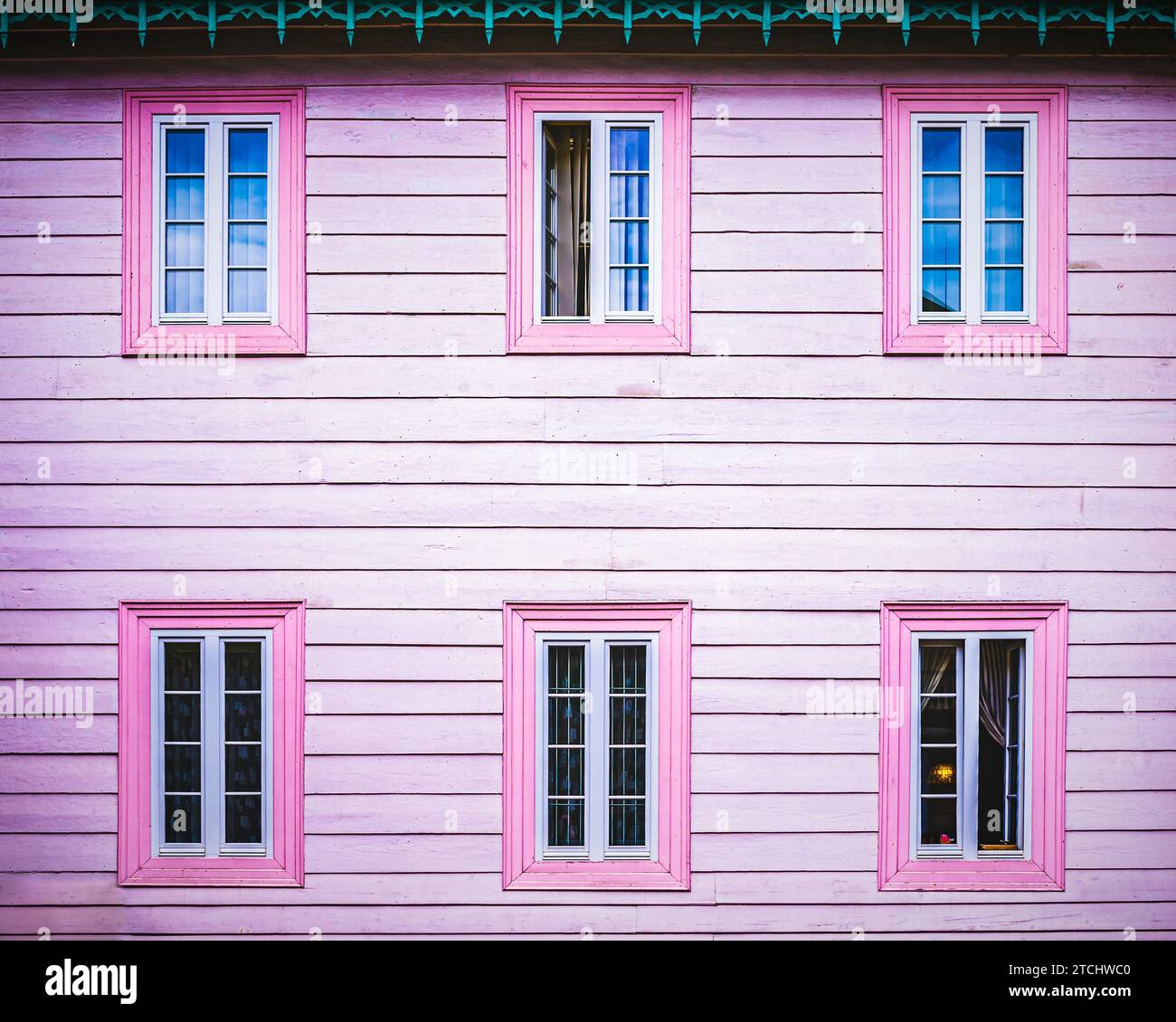 Wooden in pink color with stylish windows and green roof. Architecture ...