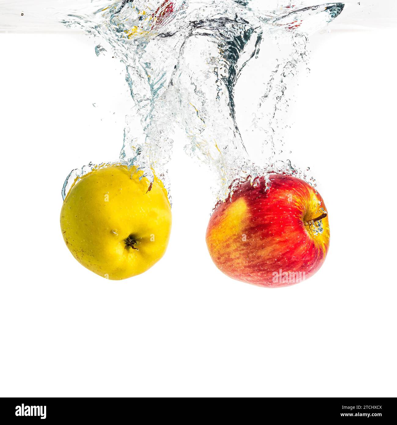 Apples causing water splash and sinking with air bubbles on white ...
