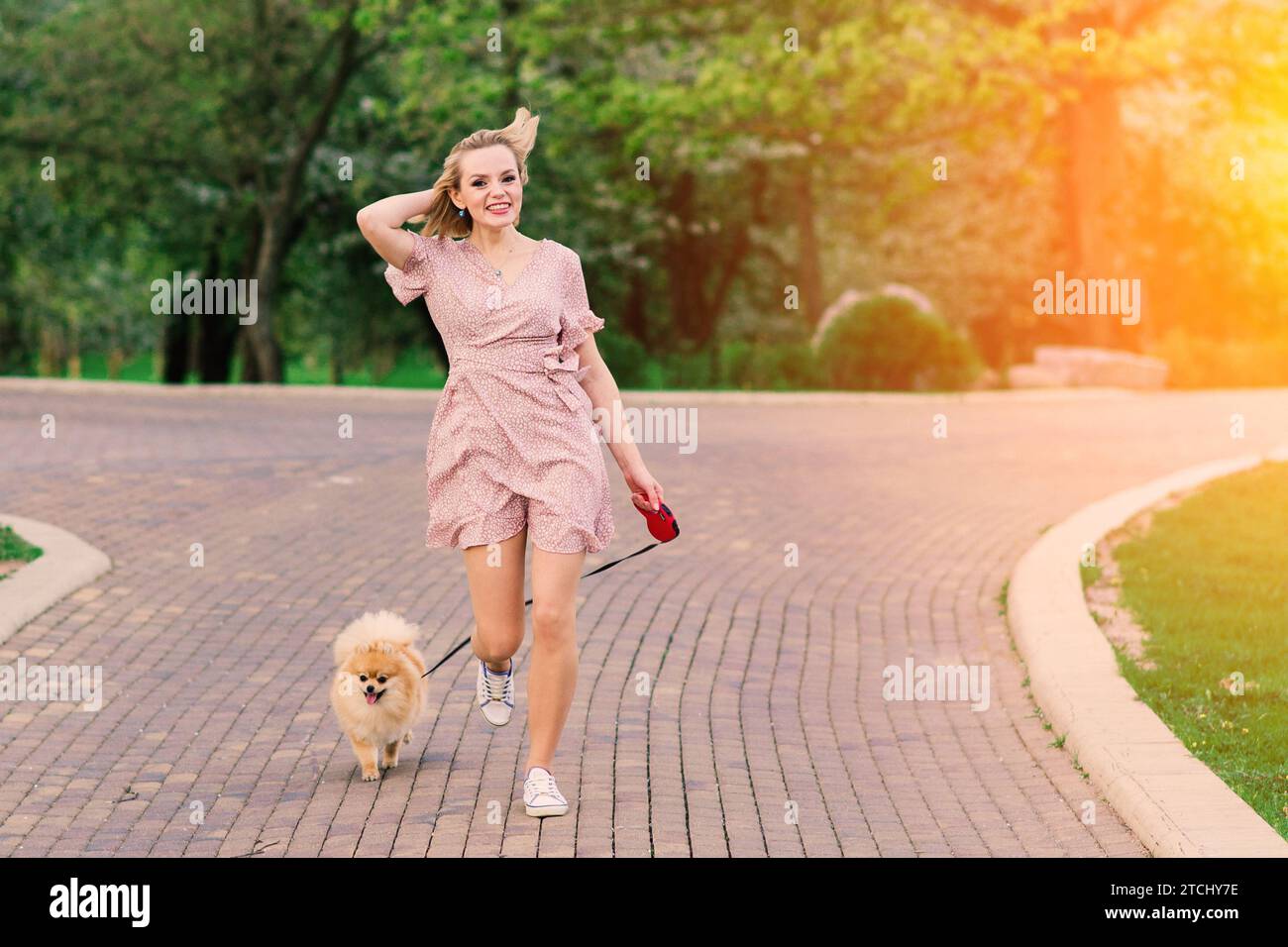 Portrait of a young glamorous female wearing pink dress holding her ...